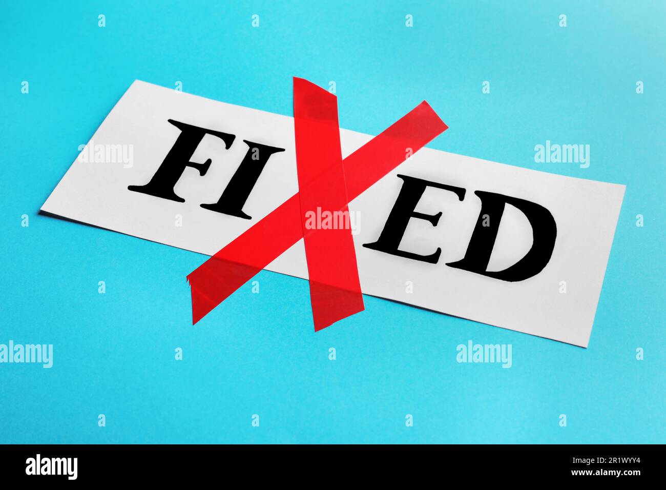 Card with optimistic word Fixed on light blue background. Letter X made ...