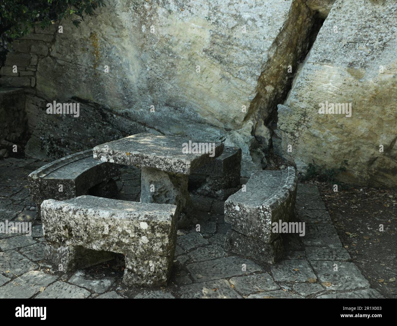 Stone table and benches near rock outdoors Stock Photo - Alamy