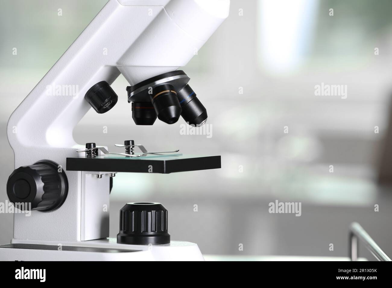 Modern medical microscope with glass slide on blurred background ...