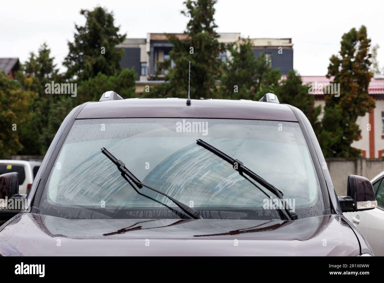 Car wipers cleaning water drops from windshield glass outdoors Stock ...