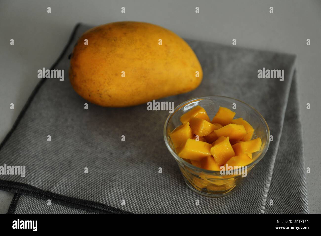 Delicious cut and whole mangoes on light table Stock Photo - Alamy