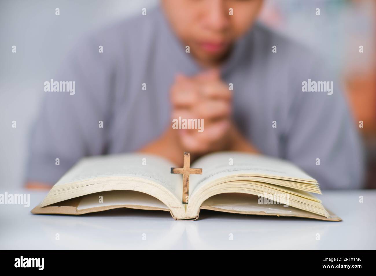 Close-up of a woman reading an open bible, praying and holding hands on ...