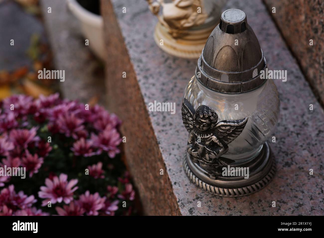 Grave lanterns and flowers on granite surface in cemetery Stock Photo - Alamy