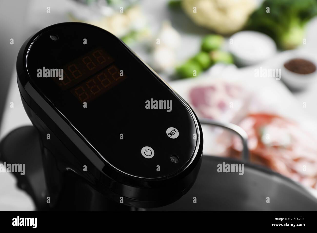 Sous vide cooker in pot on table, closeup. Thermal immersion circulator ...