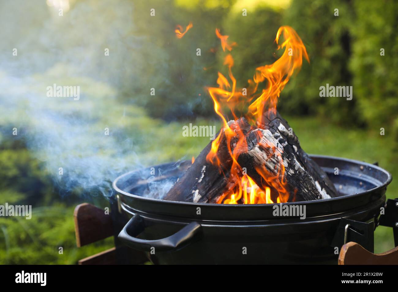 Portable barbecue grill with fire flames outdoors, closeup Stock Photo ...