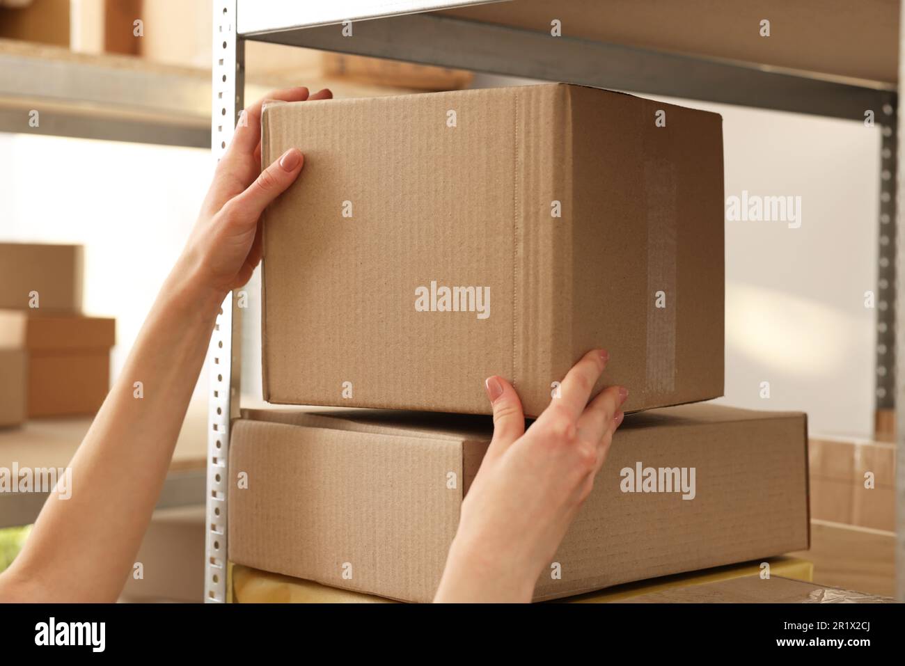 Post office worker putting box on parcel rack with parcels indoors, closeup Stock Photo - Alamy