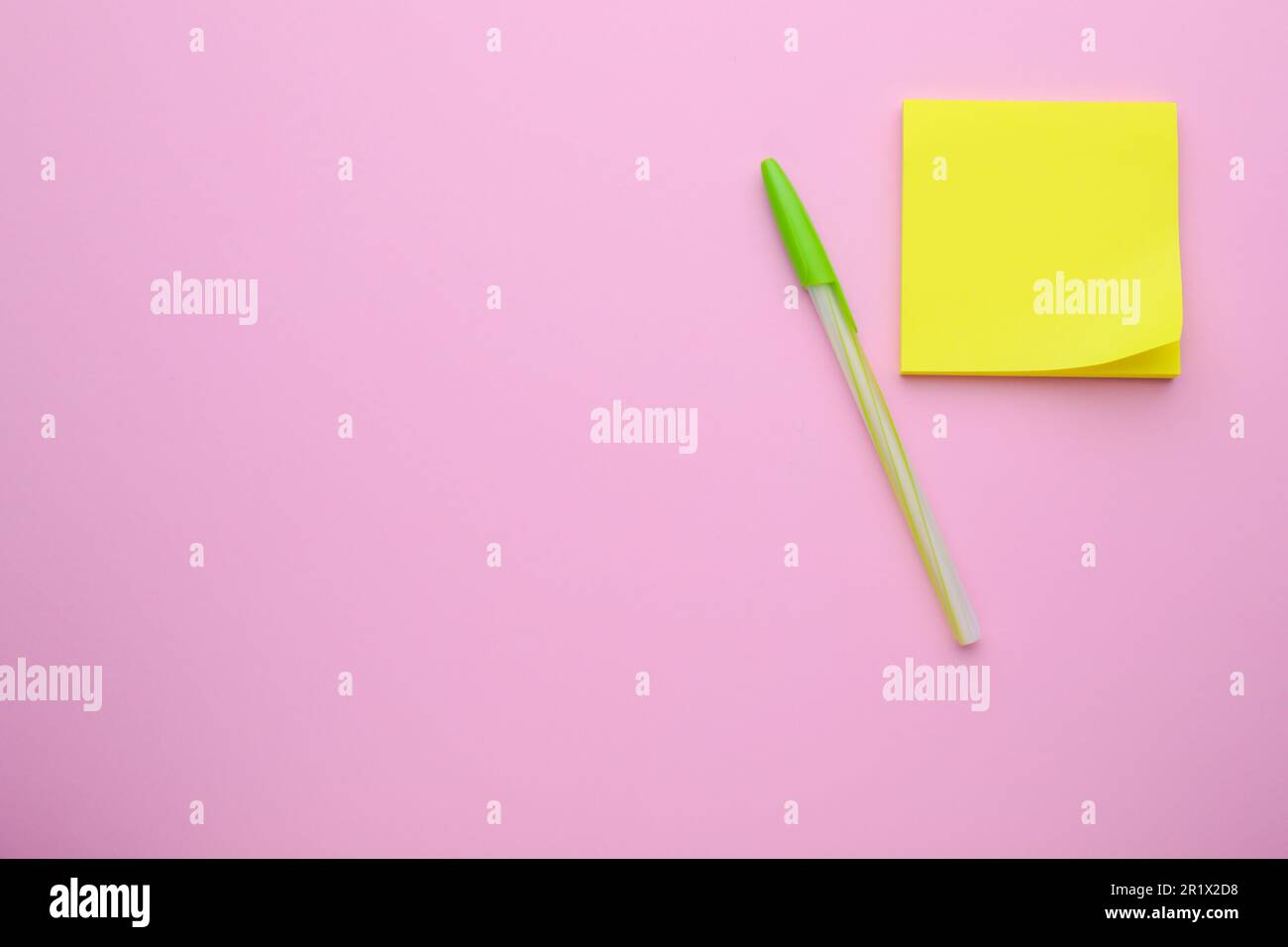 Paper note and pen on pale pink background, flat lay. Space for text ...