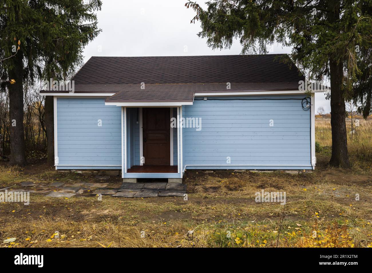 Small cozy blue house in the forest under tree Stock Photo - Alamy