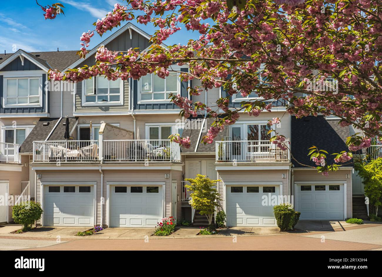 Nice neighborhood on a sunny day. Row of garage doors at parking area ...