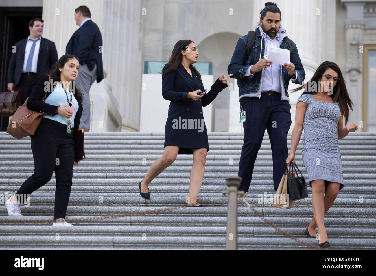 Rep. Alexandria Ocasio-Cortez (D-N.Y.) speaks with an aide as she ...