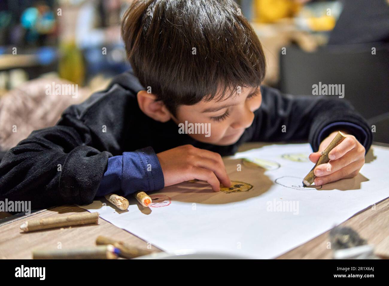 Latino little boy in a bar entertaining drawing and painting with a ...