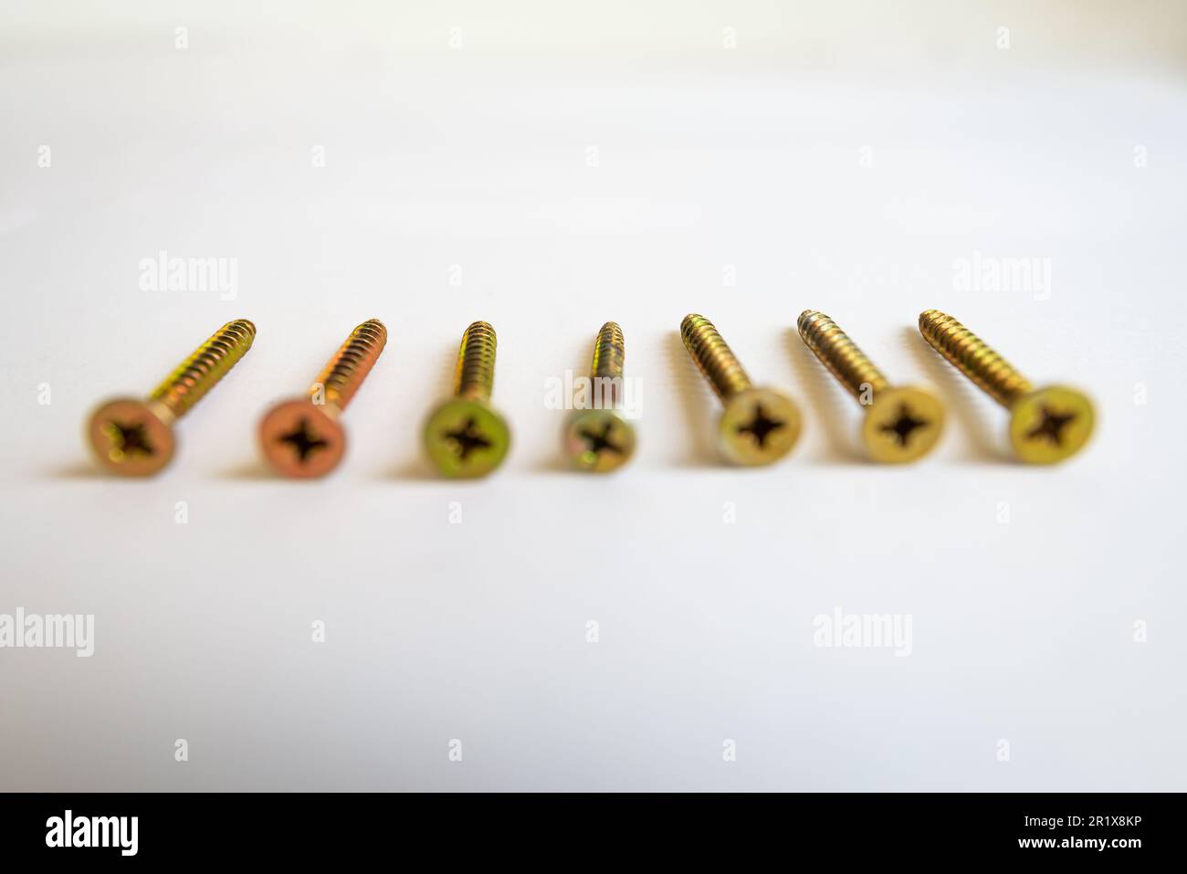 Row of gold wood screws isolated on white background Stock Photo - Alamy