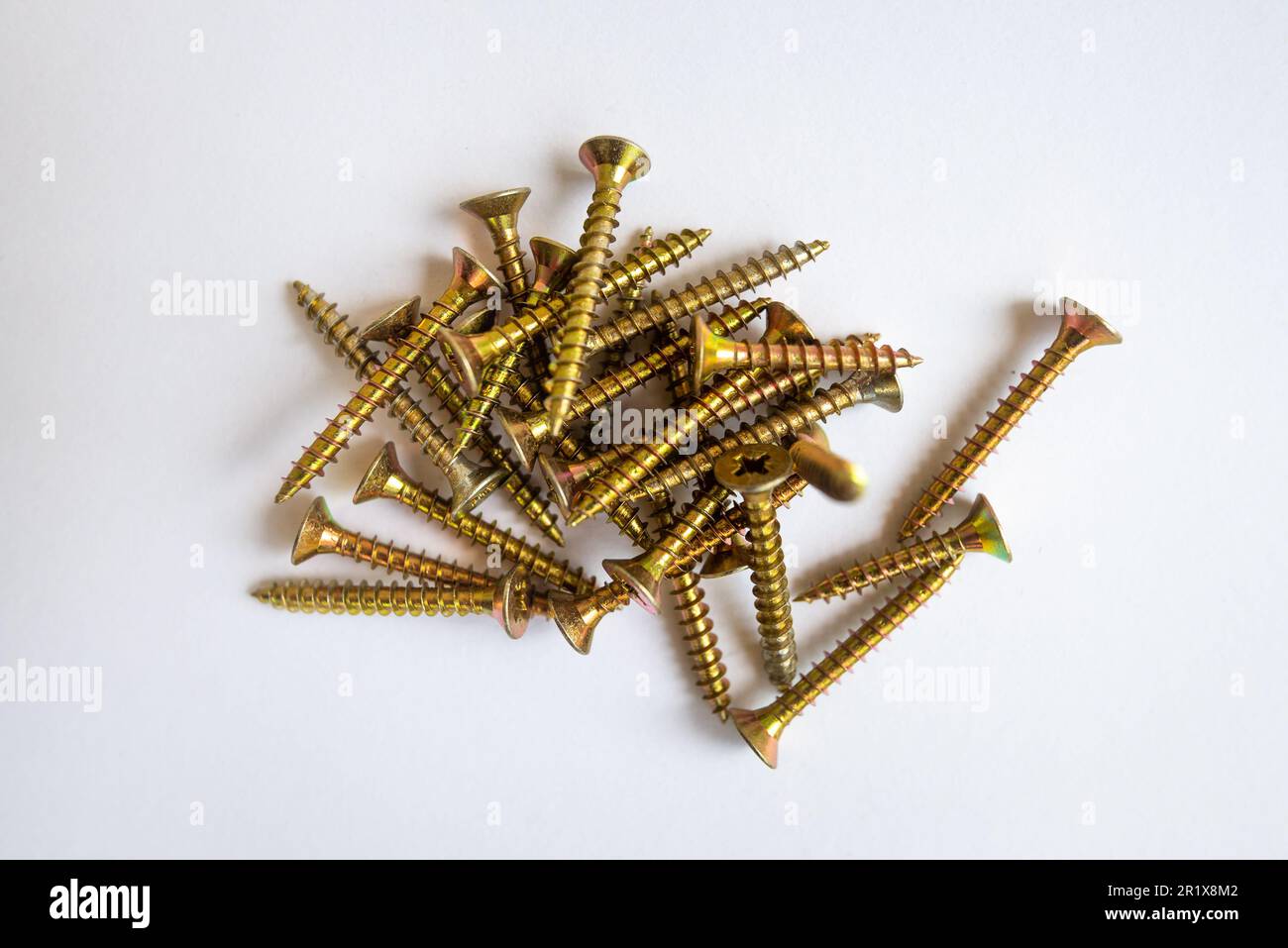 Pile of gold wood screws viewed from above isolated on white background ...