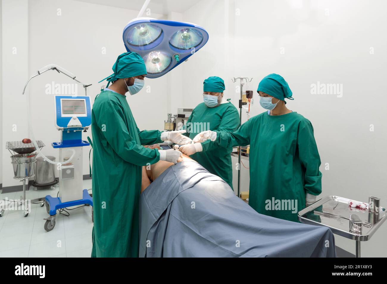 Group of surgeons and nurse in surgical green gown uniform performing ...