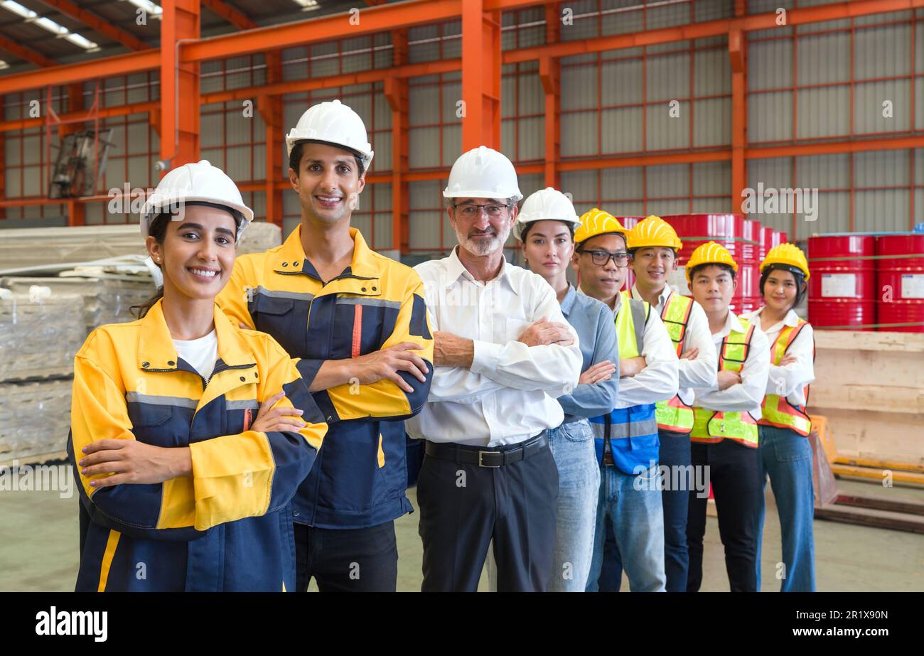 Group of male and female factory labor stand smiling together with arms ...
