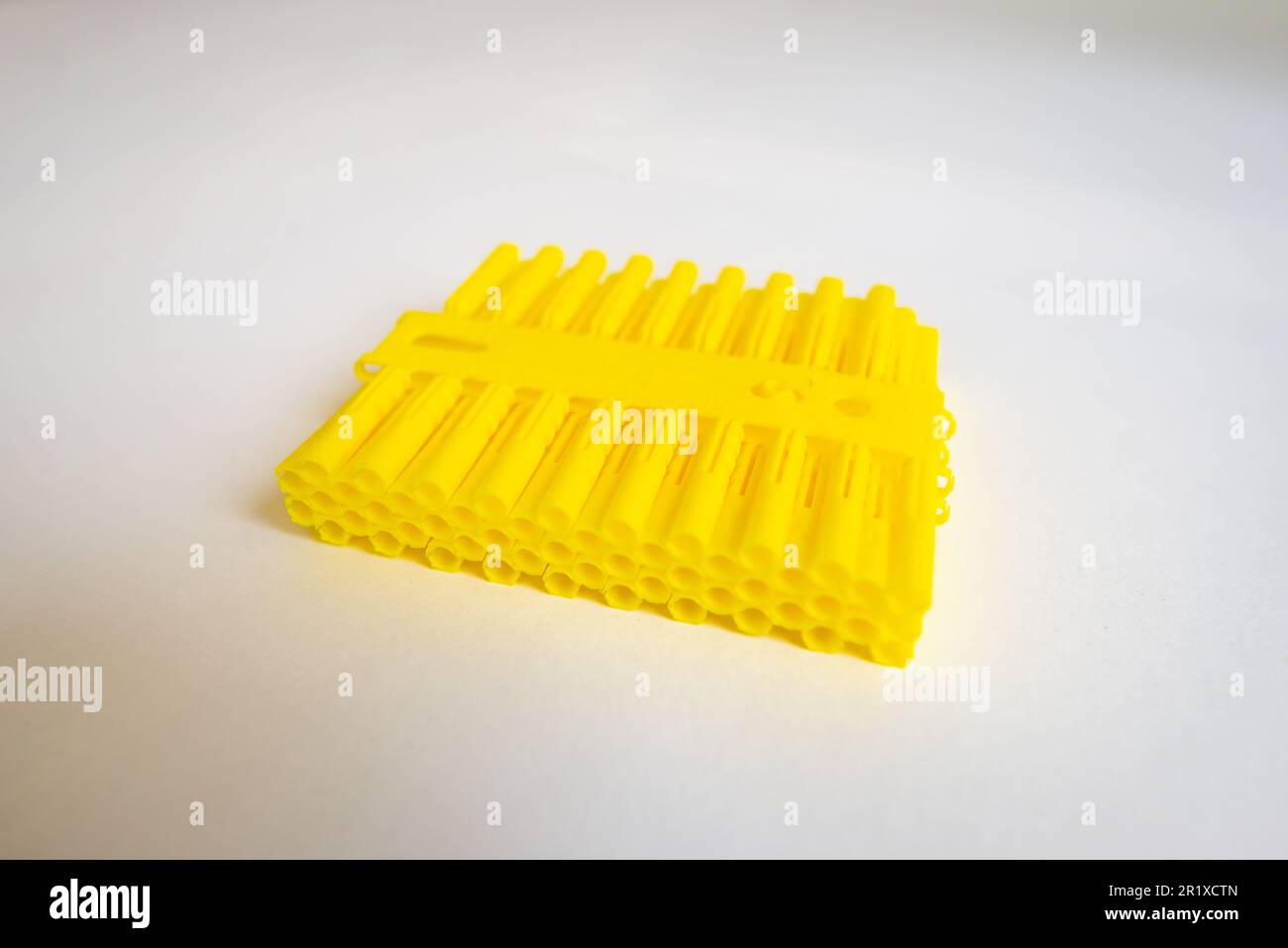 Close up of bunch of yellow plastic raw plugs. Angle view, isolated on ...