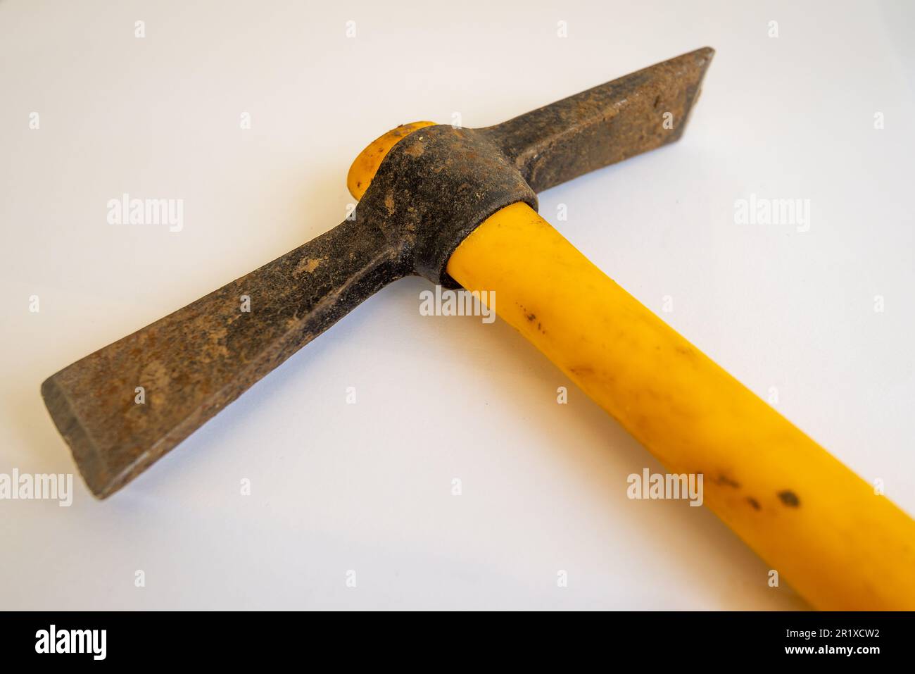 Old, used iron chisel hand tool close up with yellow handle. Isolated ...