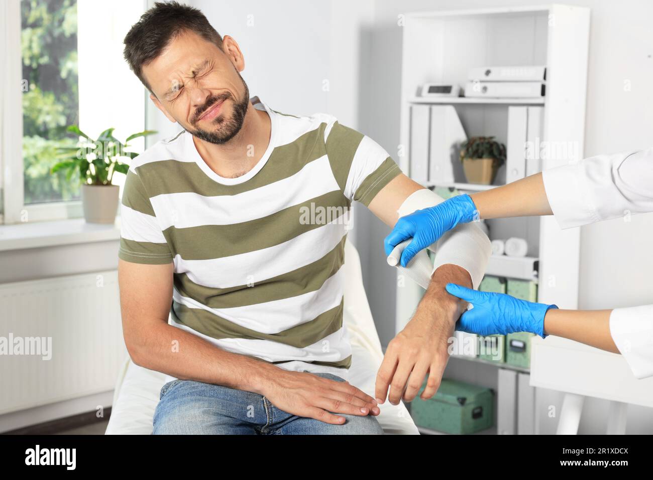 Doctor applying bandage onto patient's arm in hospital Stock Photo - Alamy