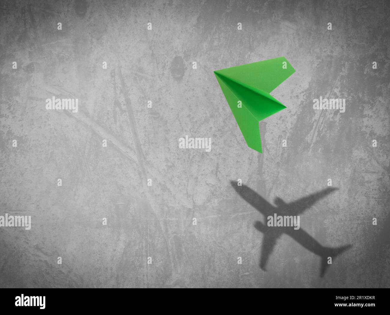 Flying paper plane and shadow of a real airplane on grey background ...