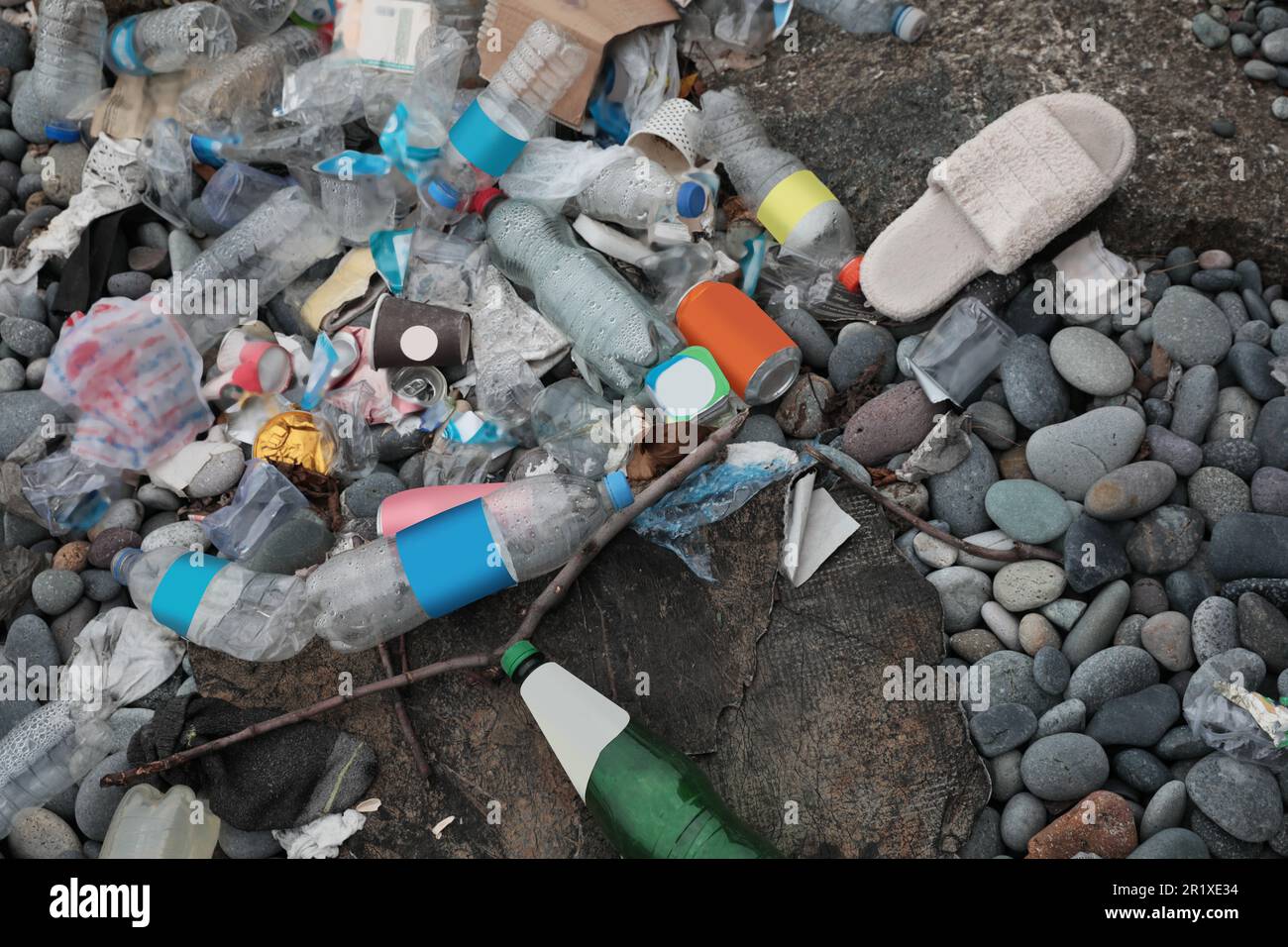 Garbage scattered on pebbles outdoors, top view. Recycling problem ...