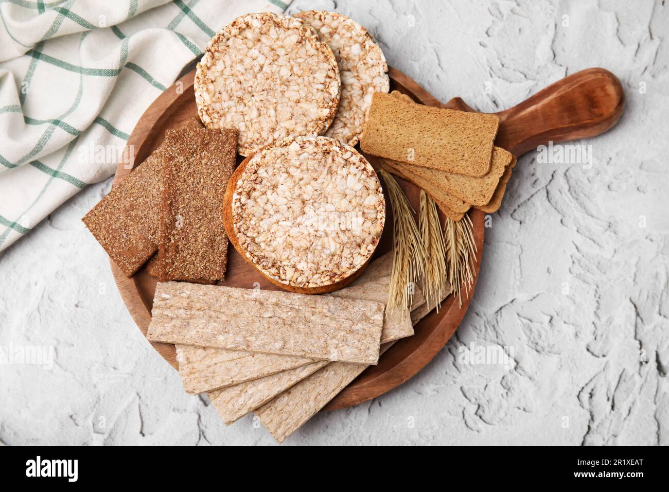 Rye crispbreads, rice cakes and rusks on white textured table, flat lay ...