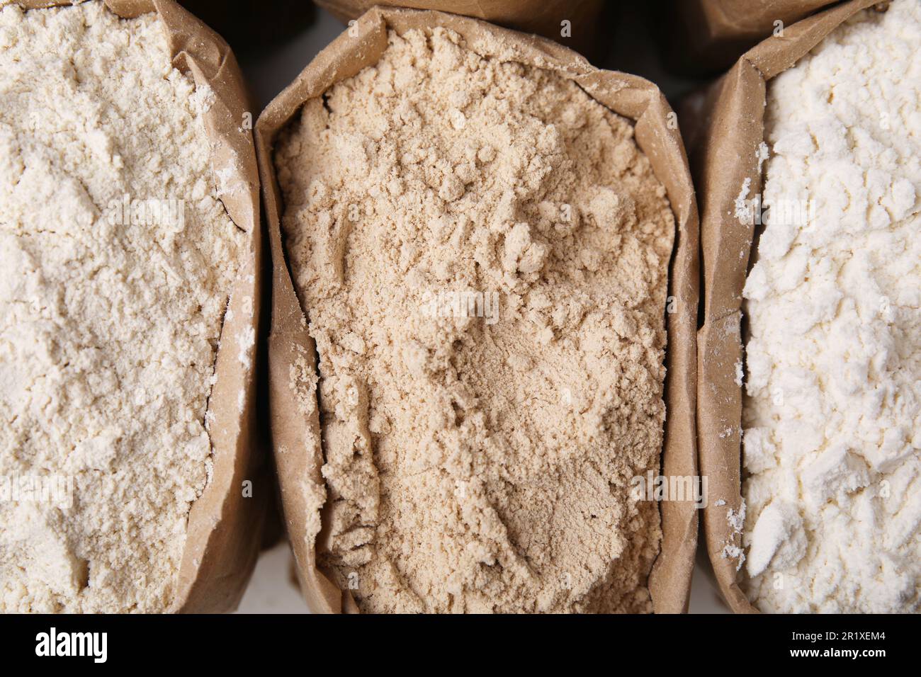 Paper sacks with different types of flour as background, closeup Stock ...