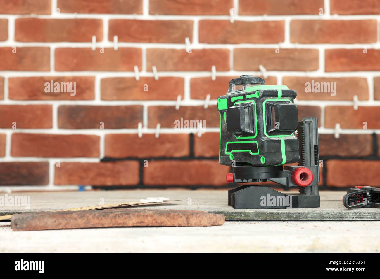 Modern cross line laser level on floor indoors, space for tex. Tiles ...