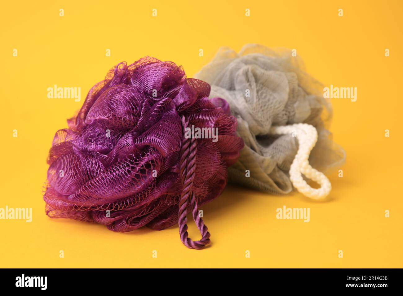 Colorful shower puffs on yellow background. Personal hygiene Stock ...