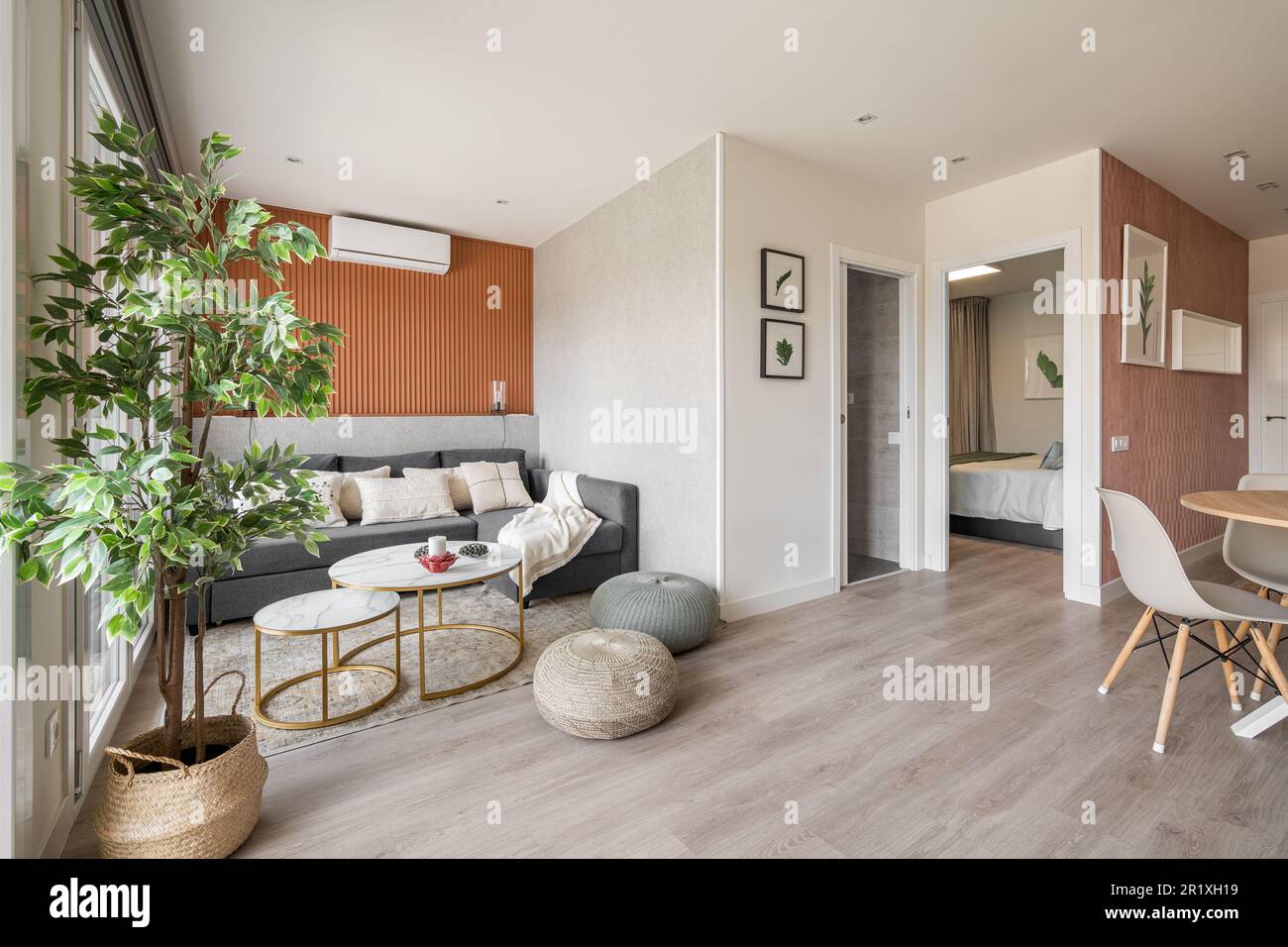 Lounge seating area with terracotta color wall with sofa and pouffes ...