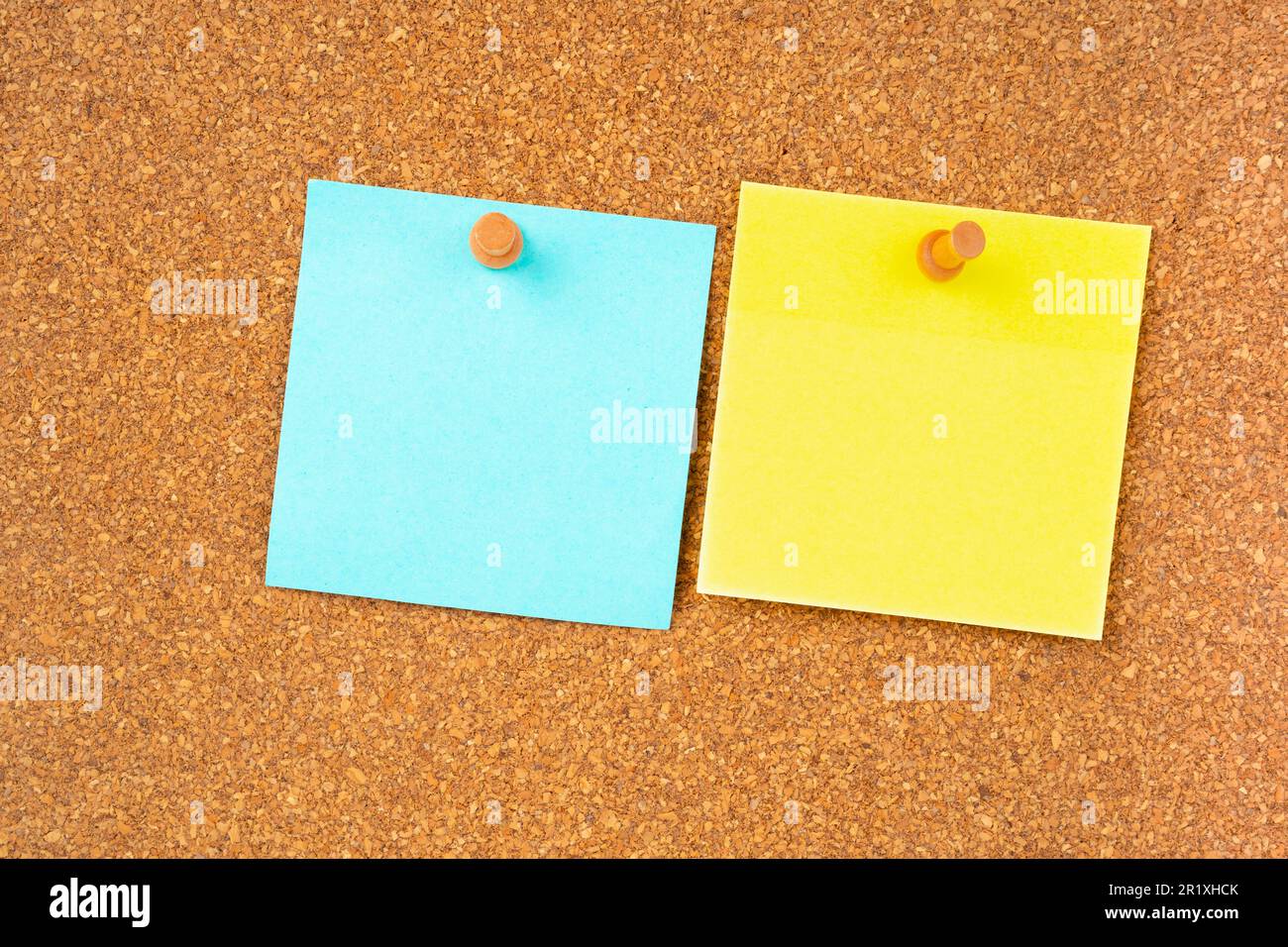 Blank yellow and blue color sticky note paper and wooden thumbtack on ...