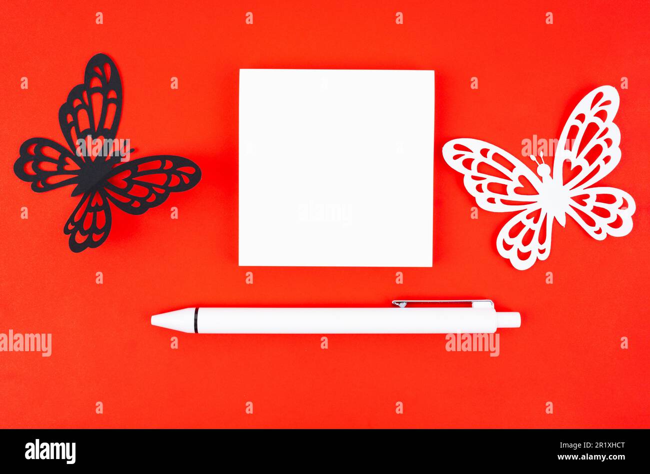 Blank reminder note paper and carve of paper butterfly with pen on red ...