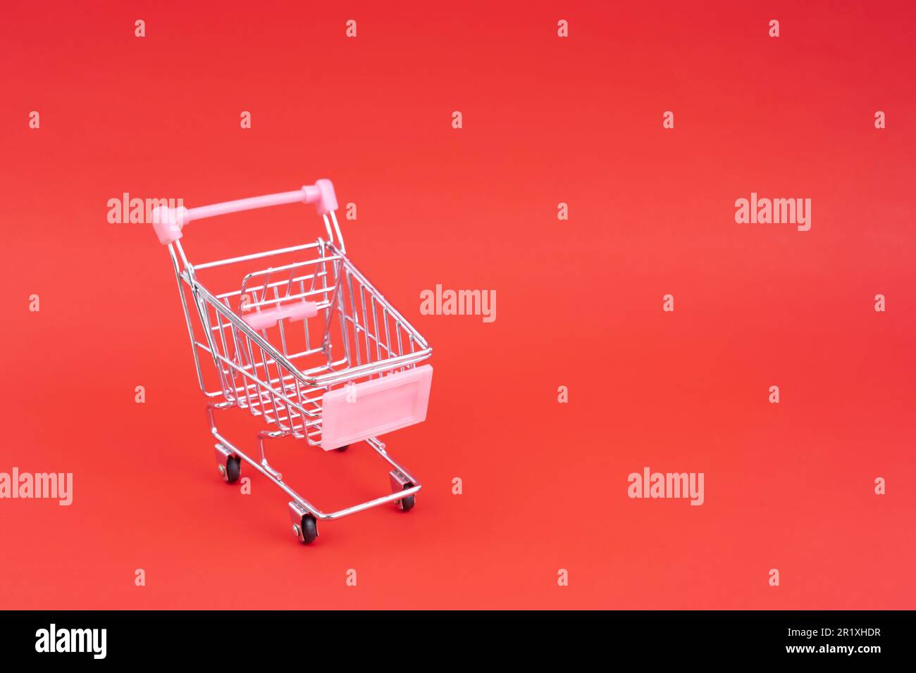 Mini shopping trolley for shopping on red background, consumer concept ...