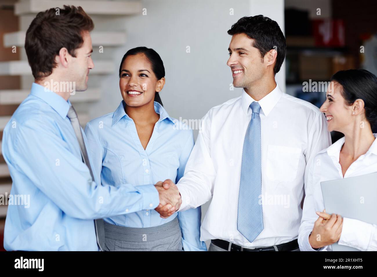 Welcome to the team. Two businessmen sealing the deal with a handshake ...
