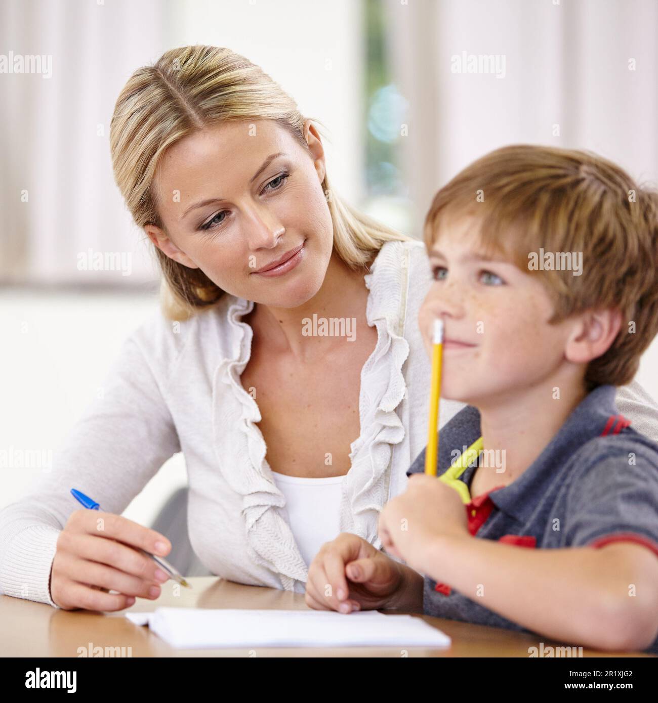 Guiding and inspiring her students. A young teacher assisting a student ...