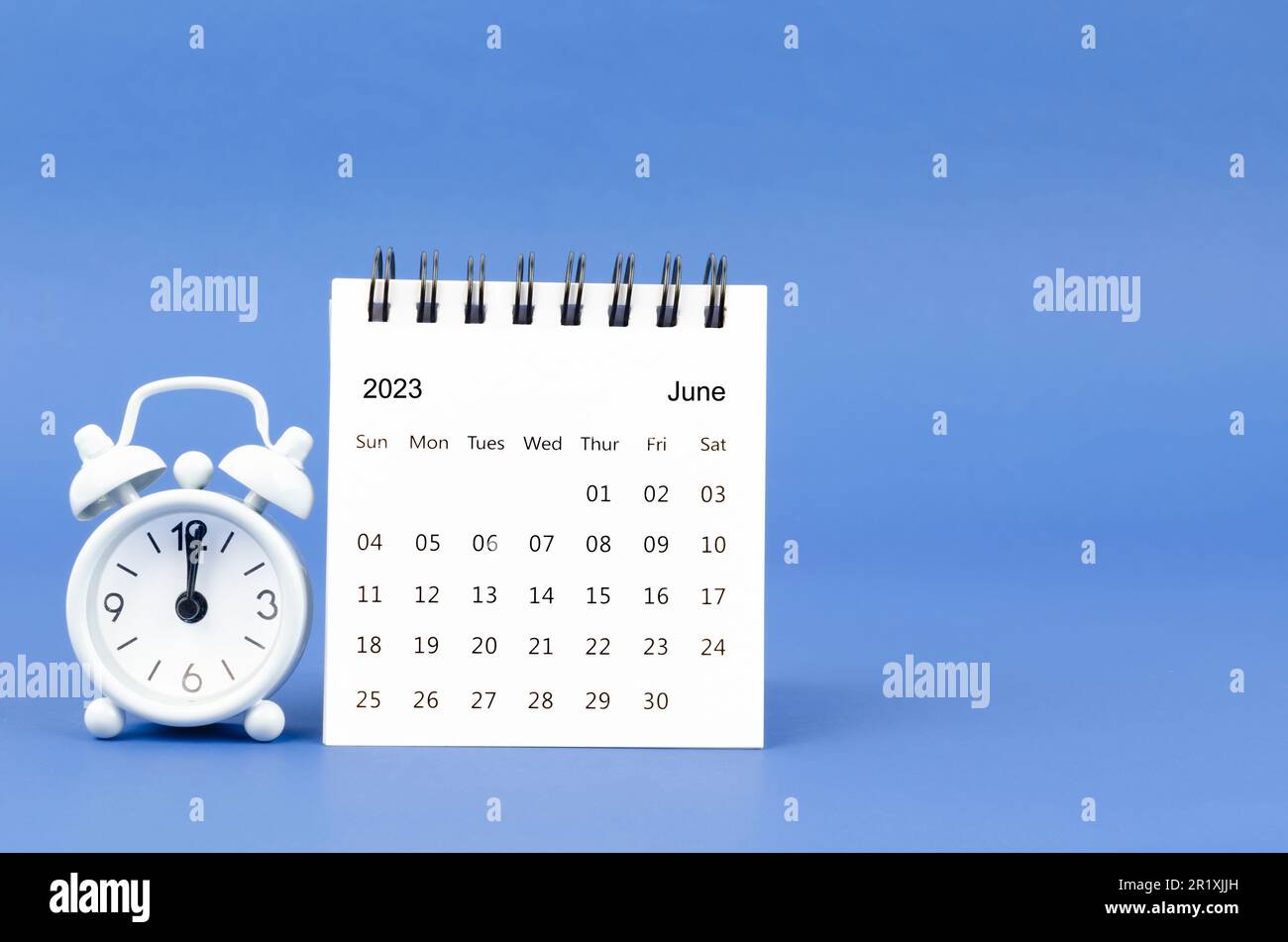 June 2023 desk calendar and alarm clock on blue color background Stock ...
