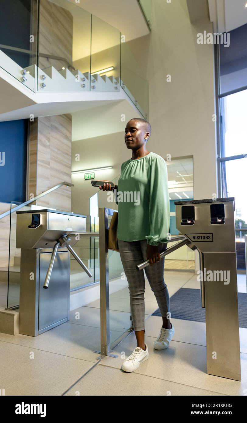 African american businesswoman with short hair entering from turnstile ...