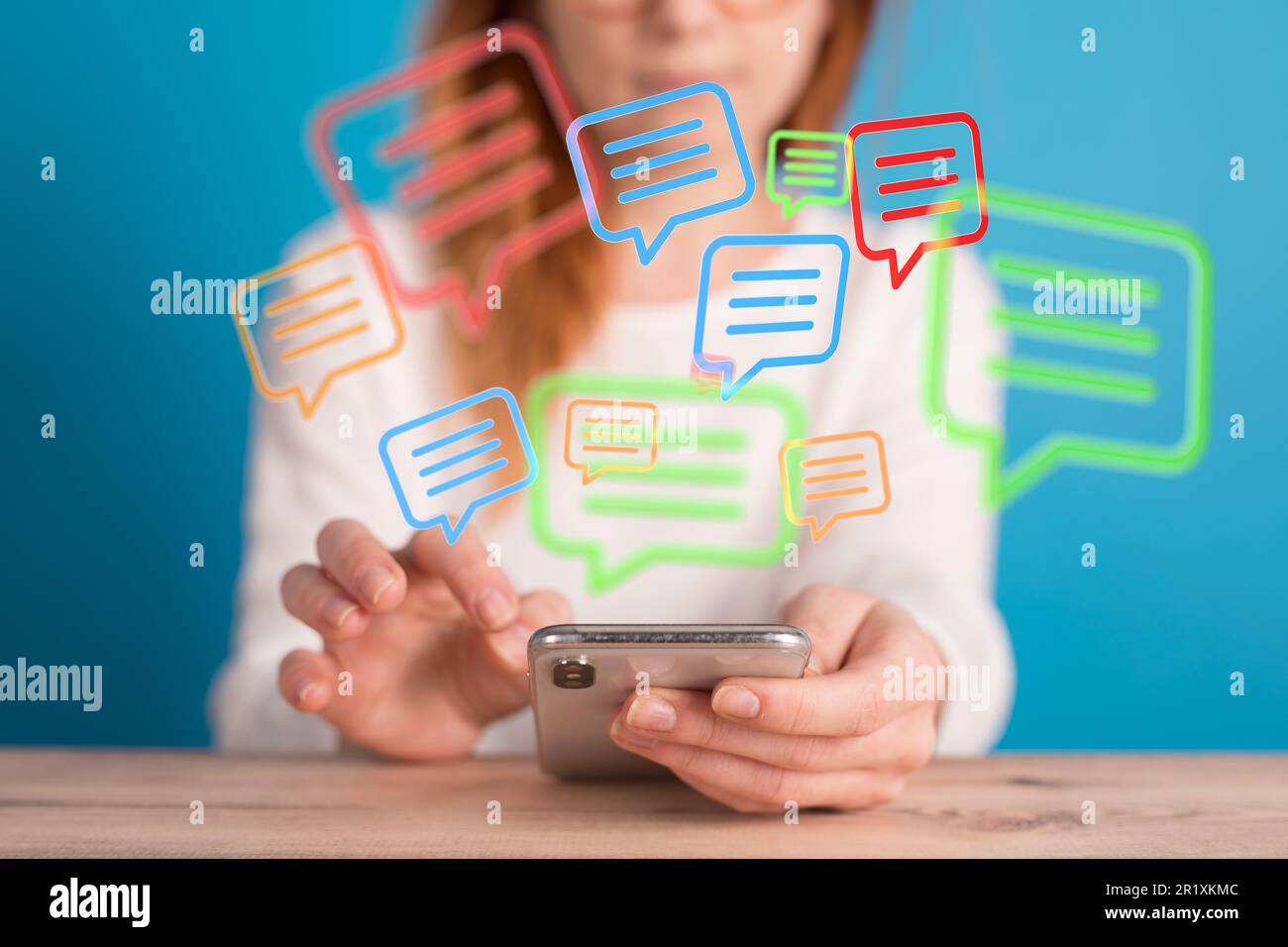 A young female is looking at her cellphone with a variety of colorful ...