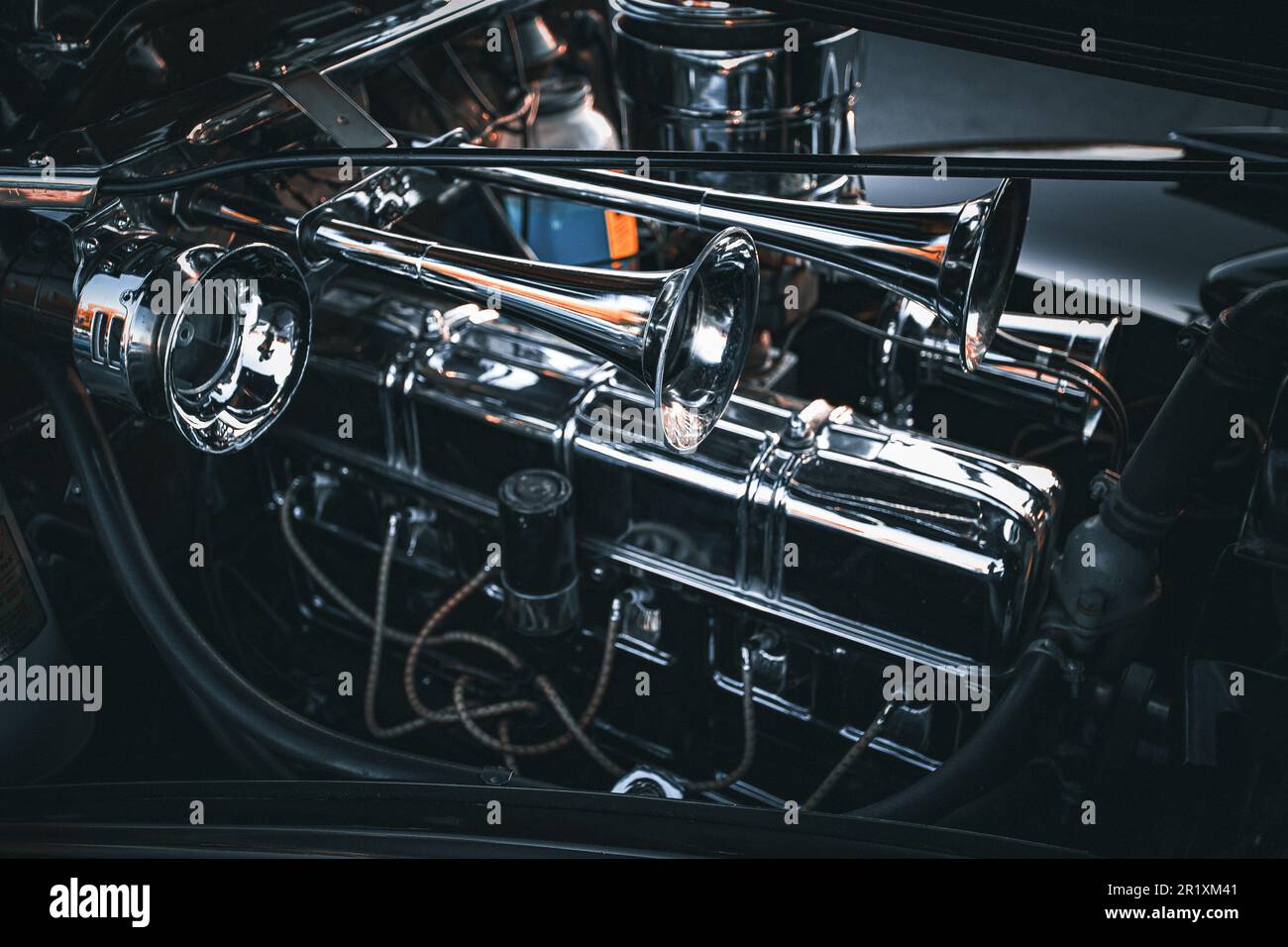 A closeup of a high-shine chrome car engine in a dark, industrial ...