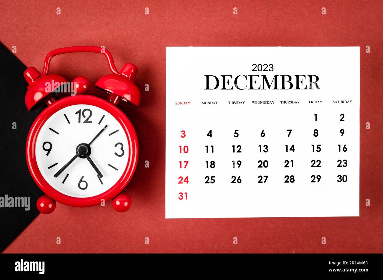December 2023 Monthly calendar year with alarm clock on red and black ...