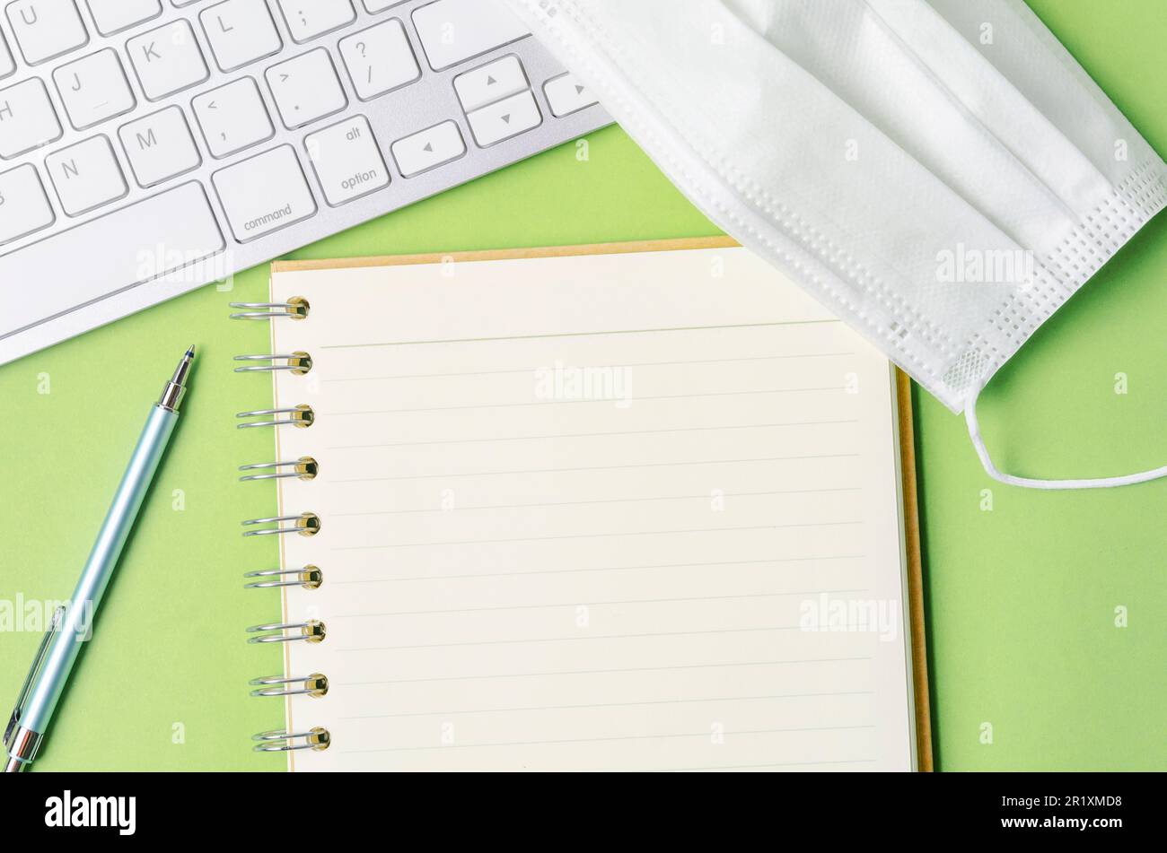 Open blank diary and keyboard computer with disposable face mask on ...