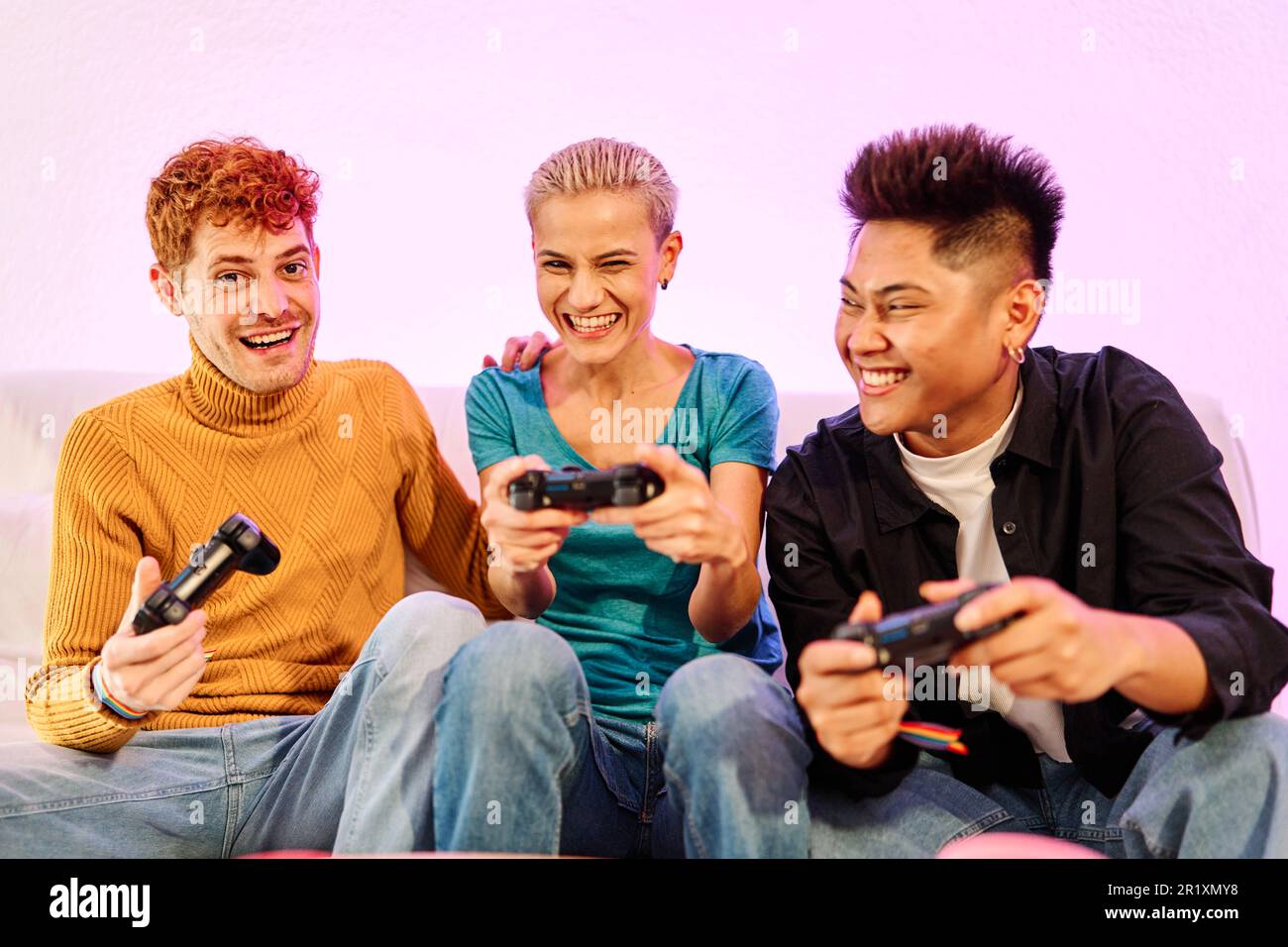 Happy multiethnic friends playing console at home Stock Photo - Alamy
