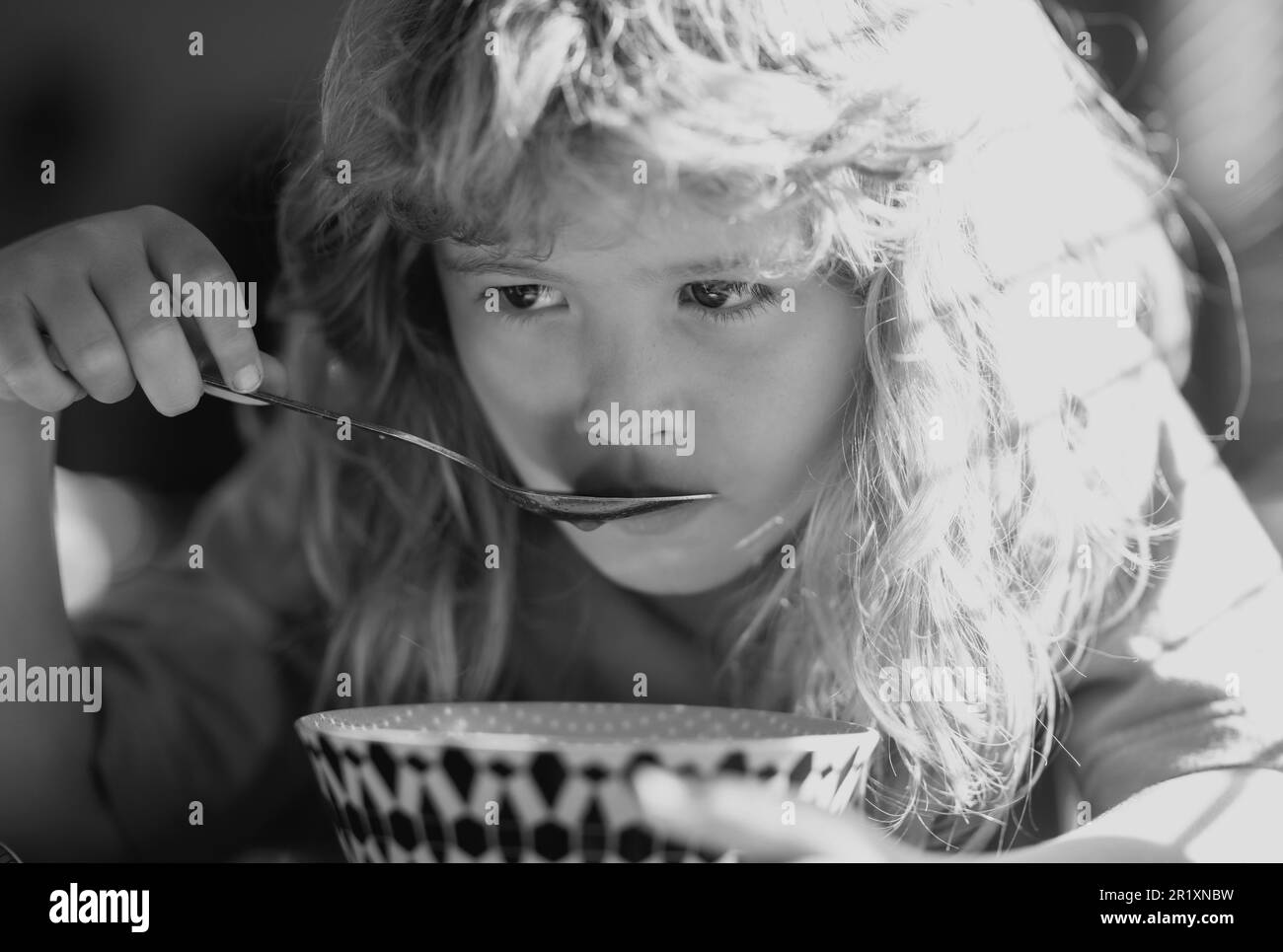 Cute child eats food itself with spoon. Little kid are eating soup ...