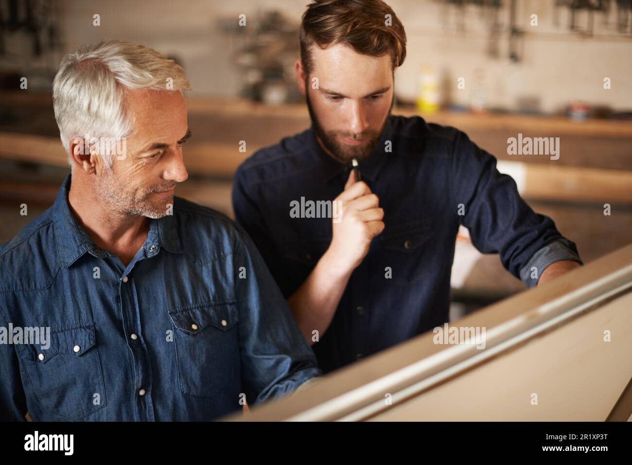 Adding up their brain power. a father and son working on a building ...