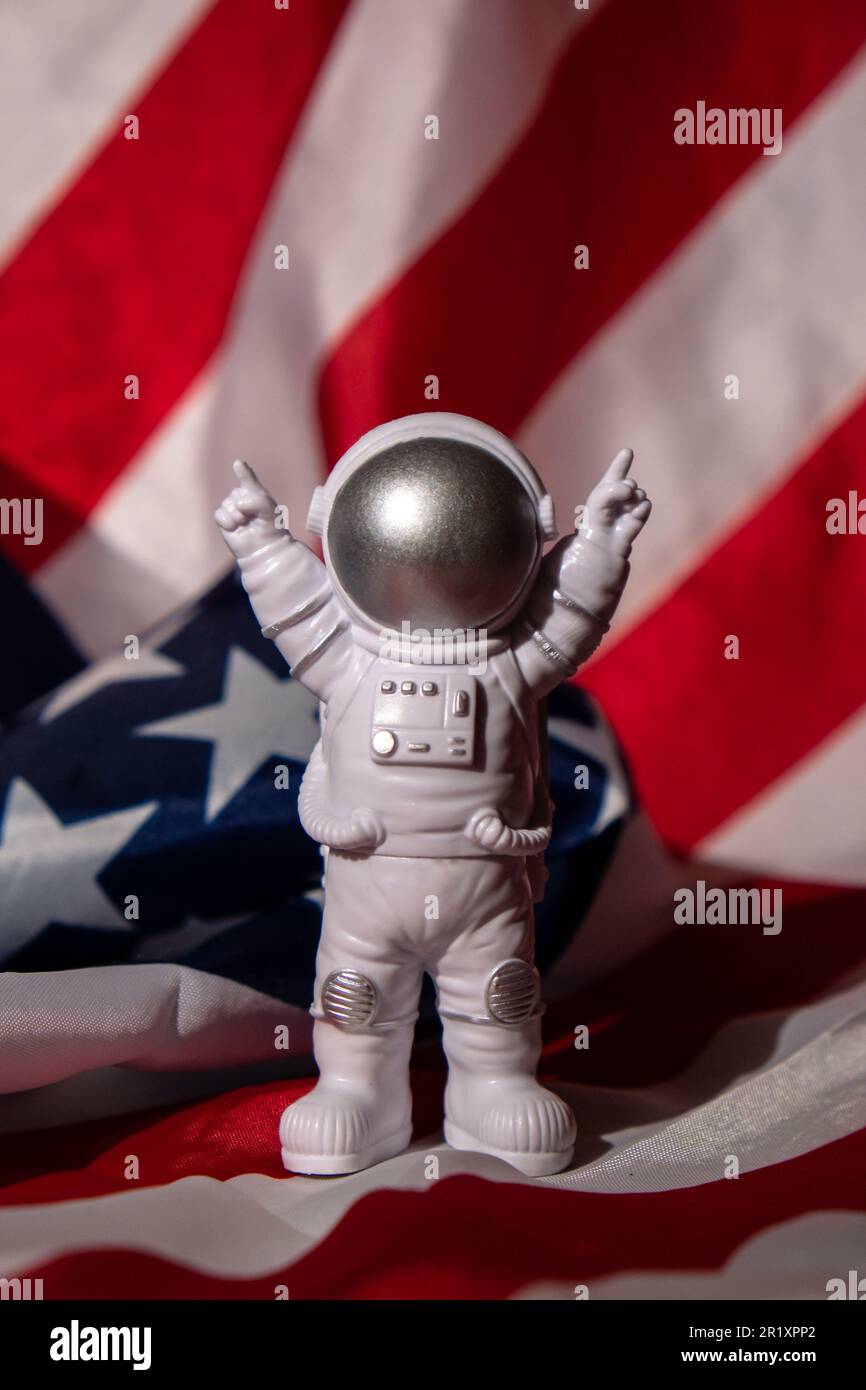 Plastic toy figure astronaut on American flag background Copy space ...