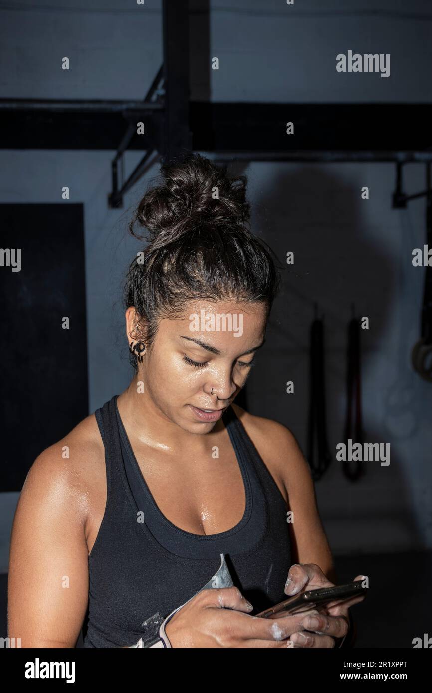 Fitness Enthusiast Multitasking with Smartphone at Gym for Balanced ...