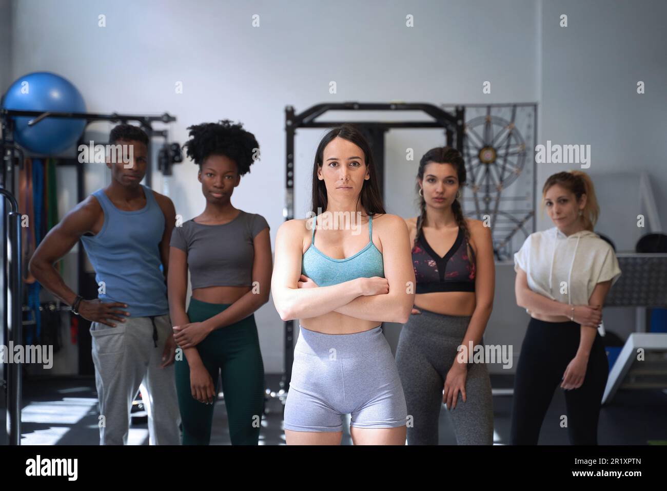 Confident female trainer standing in front of team at the gym. Sport ...