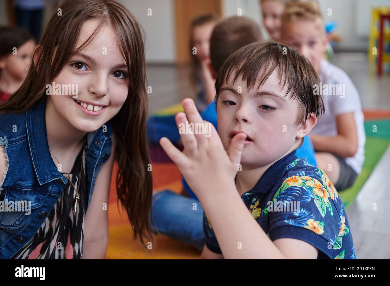 A girl and a boy with Down's syndrome in each other's arms spend time ...