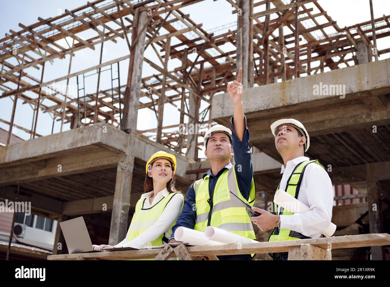 Asian Architector and engineers team with draft plan of building and ...