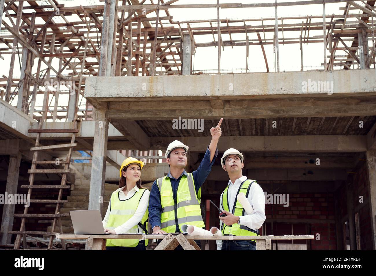 Asian Architector and engineers team with draft plan of building and ...