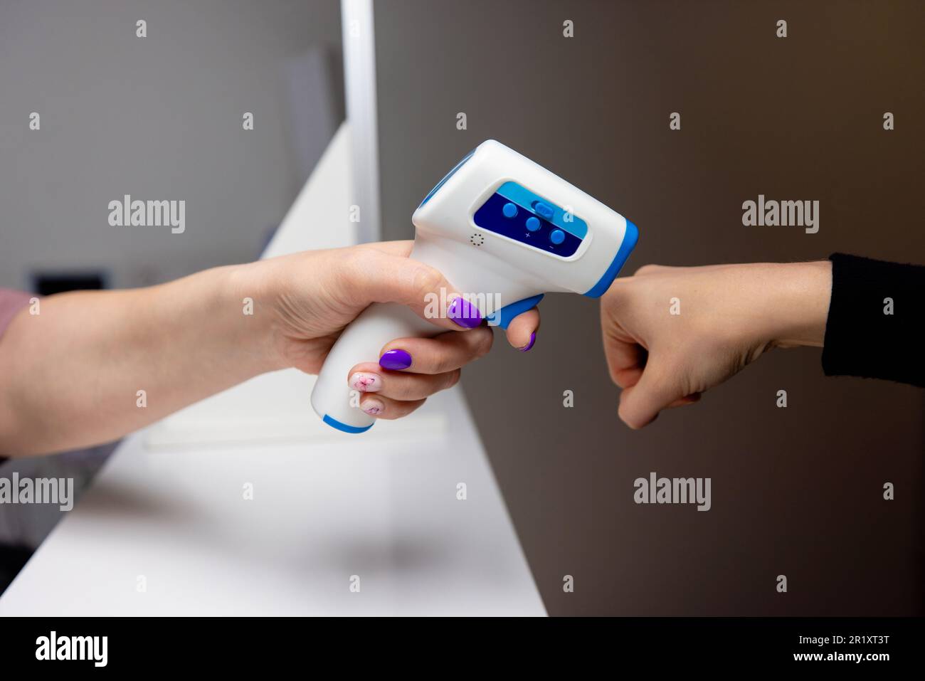 checking body temperature at the entrance to the office. Covid Stock ...